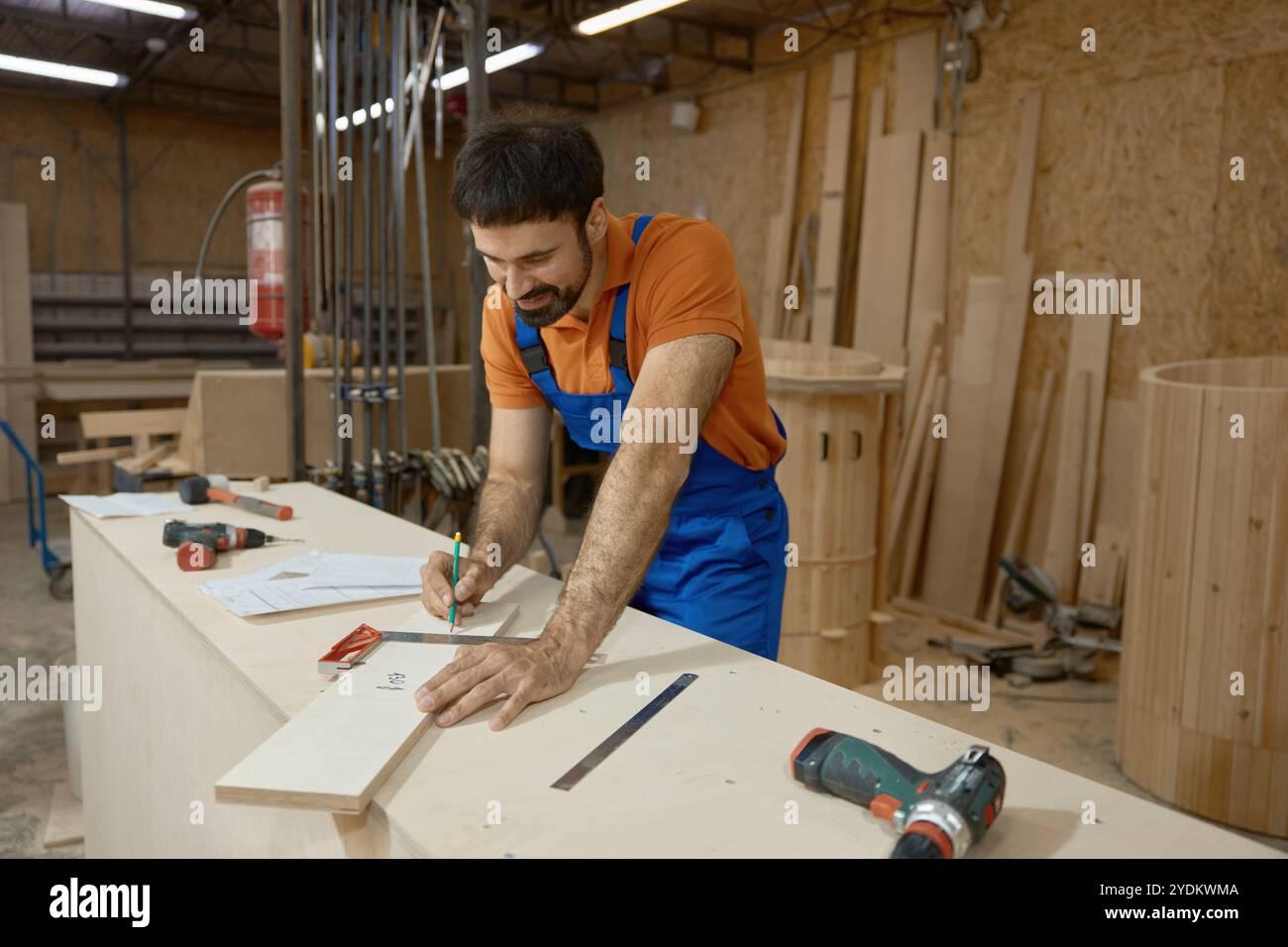 Carpenter measuring with ruler during furniture production process at ...