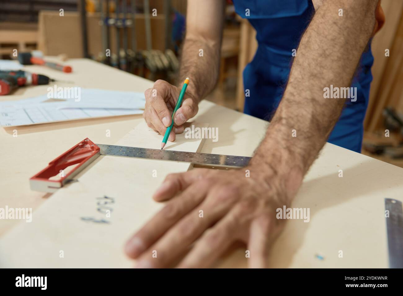 Carpenter measuring with ruler during furniture production process at ...