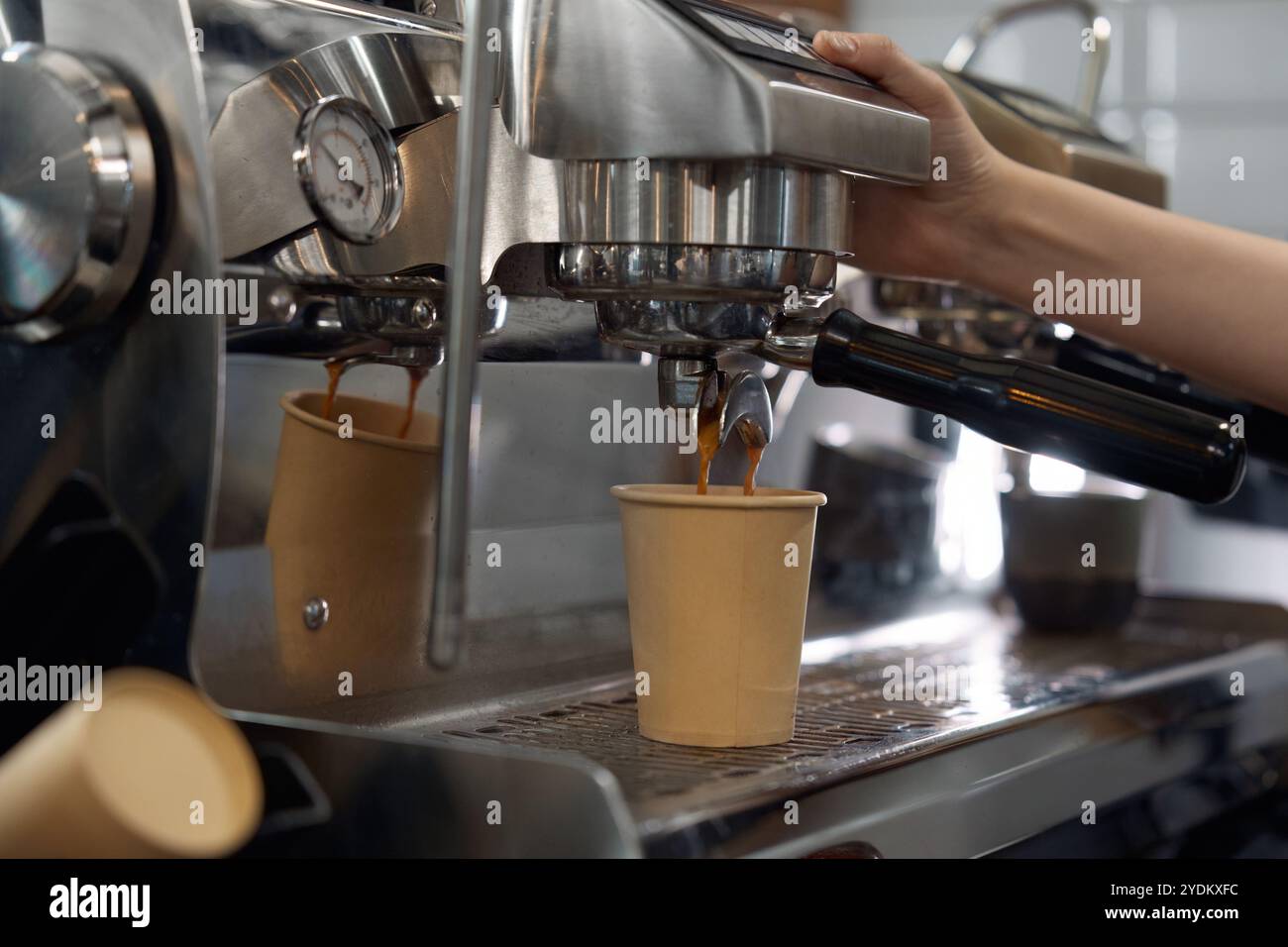 Closeup barista controlling process of espresso making with coffee ...