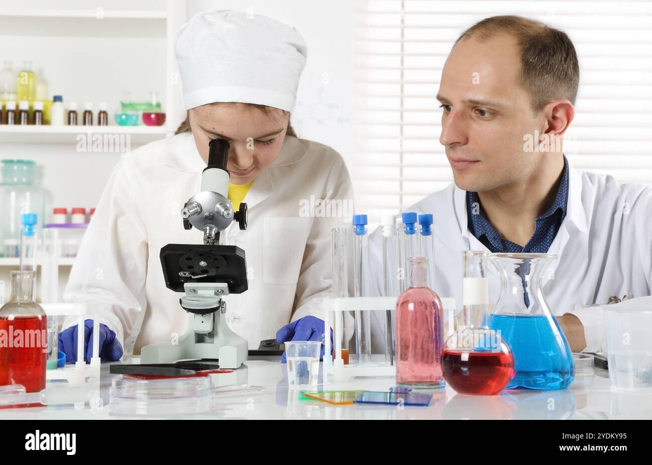A young scientist conducts classes in biochemistry with a little girl ...
