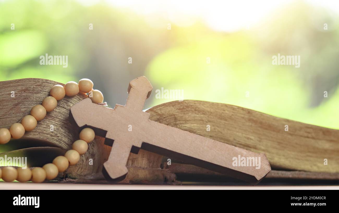 Brown wooden cross on an old open book symbolizing the spread of Jesus ...