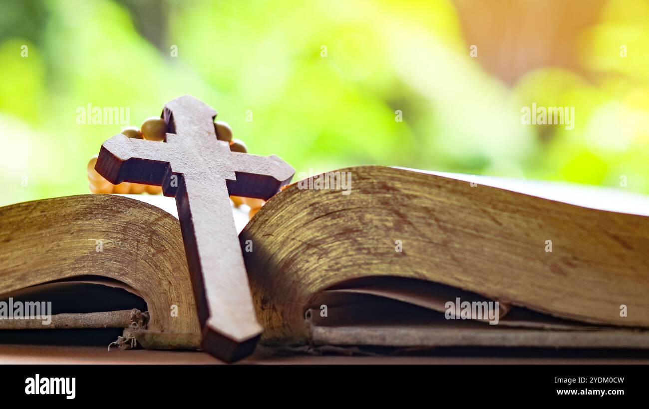 Brown wooden cross on an old open book symbolizing the spread of Jesus ...