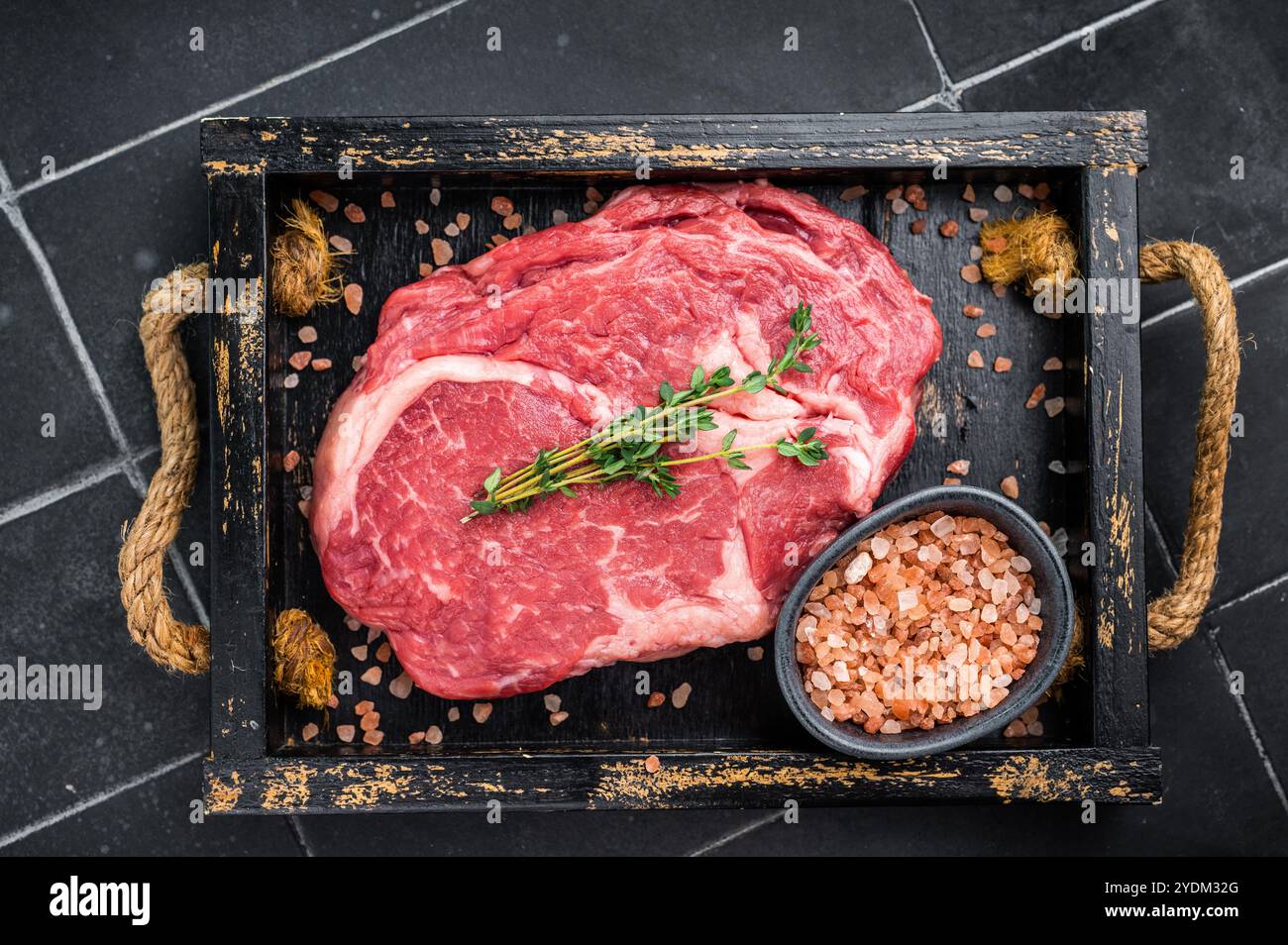 Marbled raw Rib eye steak with herbs in wooden tray, fresh beef meat ...