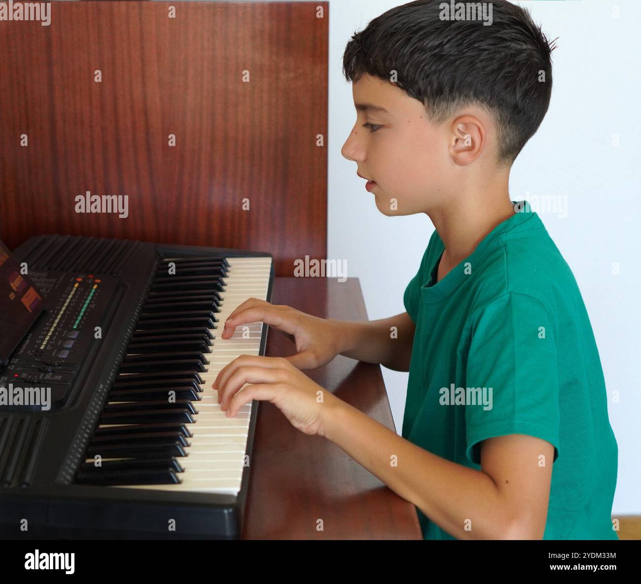 preteen child using app and tablet to learn to play keyboard or piano ...