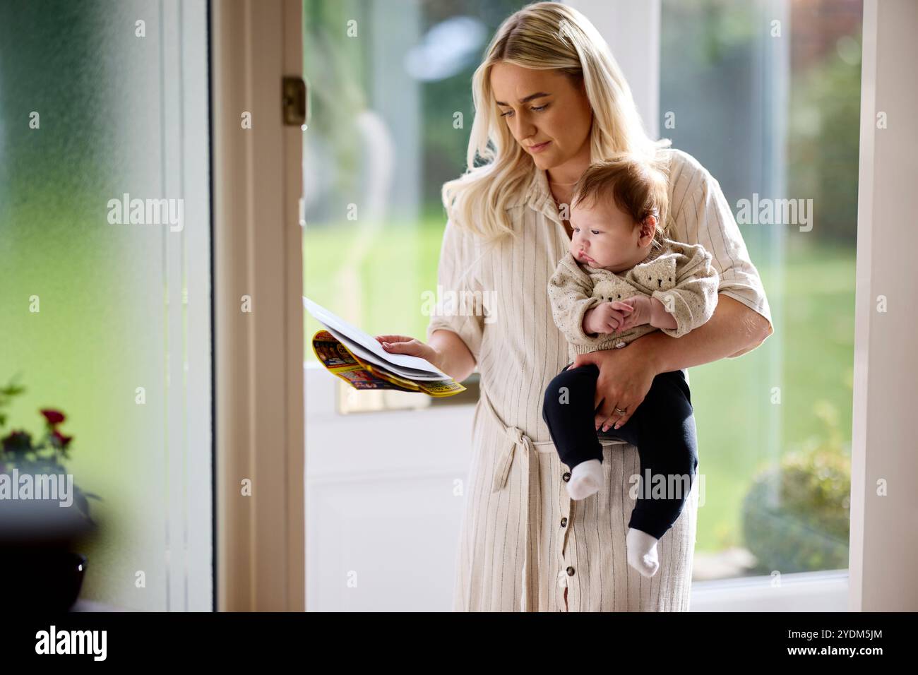 Mother and baby collecting post from front door Stock Photo - Alamy