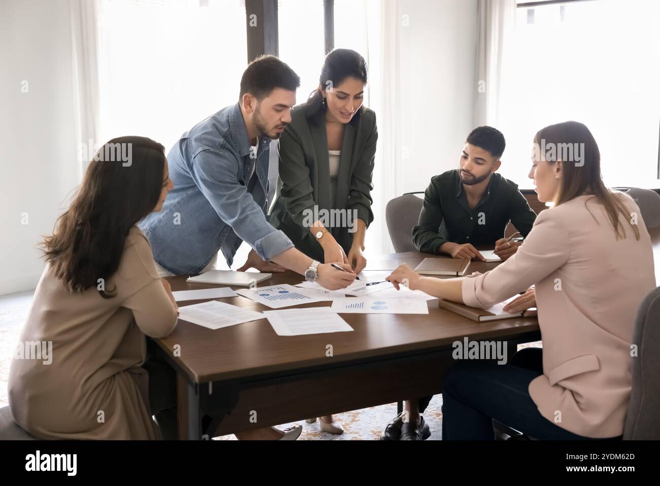 Focused busy diverse project colleagues analyzing sales statistic ...