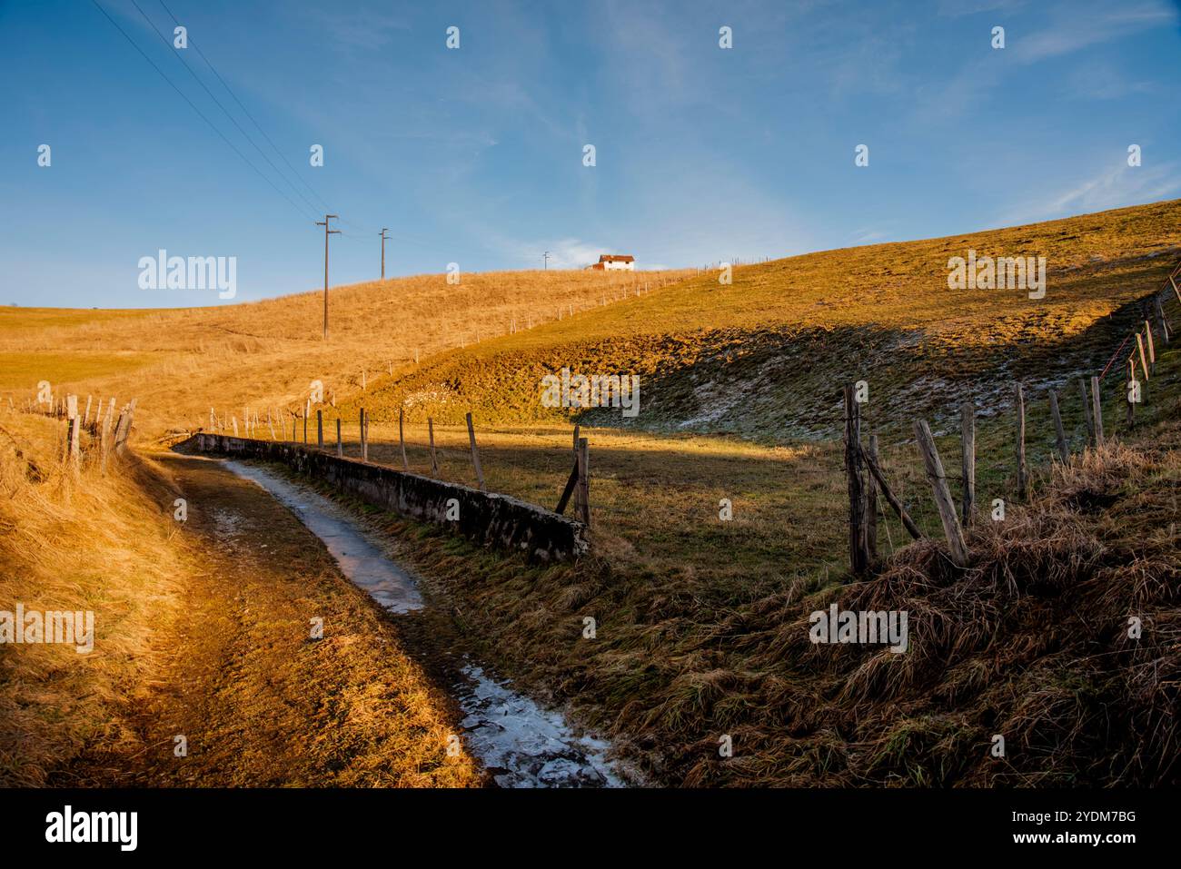 arid mountain path with stones marking the route and barbed wire ...