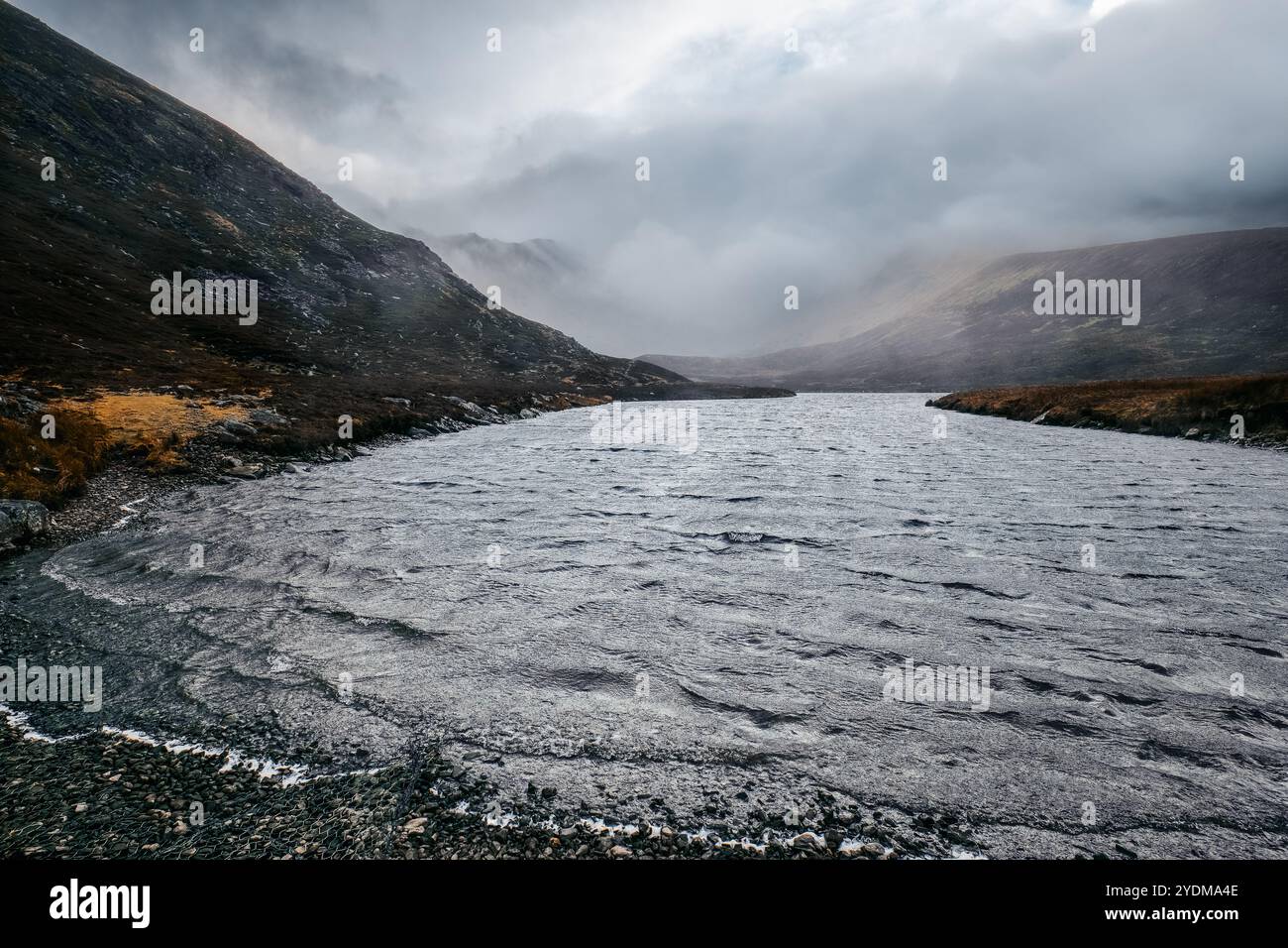 A misty, brooding landscape with rolling hills and a winding, gray ...