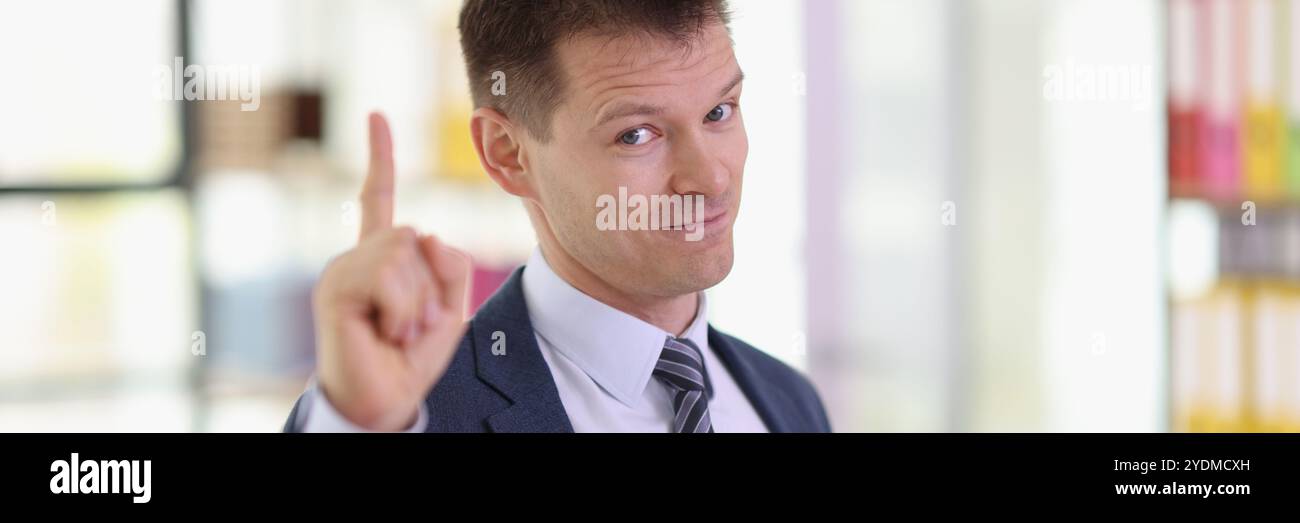 Positive businessman points up standing in company office Stock Photo ...