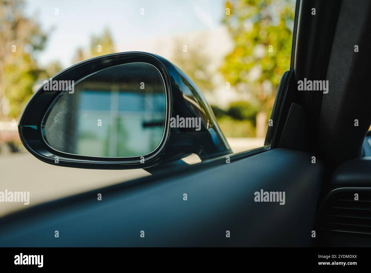 Side mirror reflection showing a closer view of objects on a black car ...