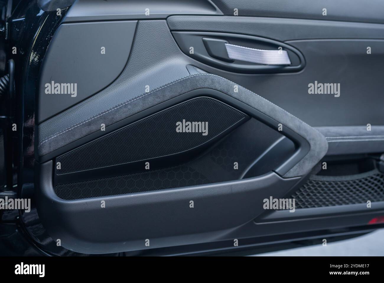 Luxury car door interior with fabric pull handle and window controls ...