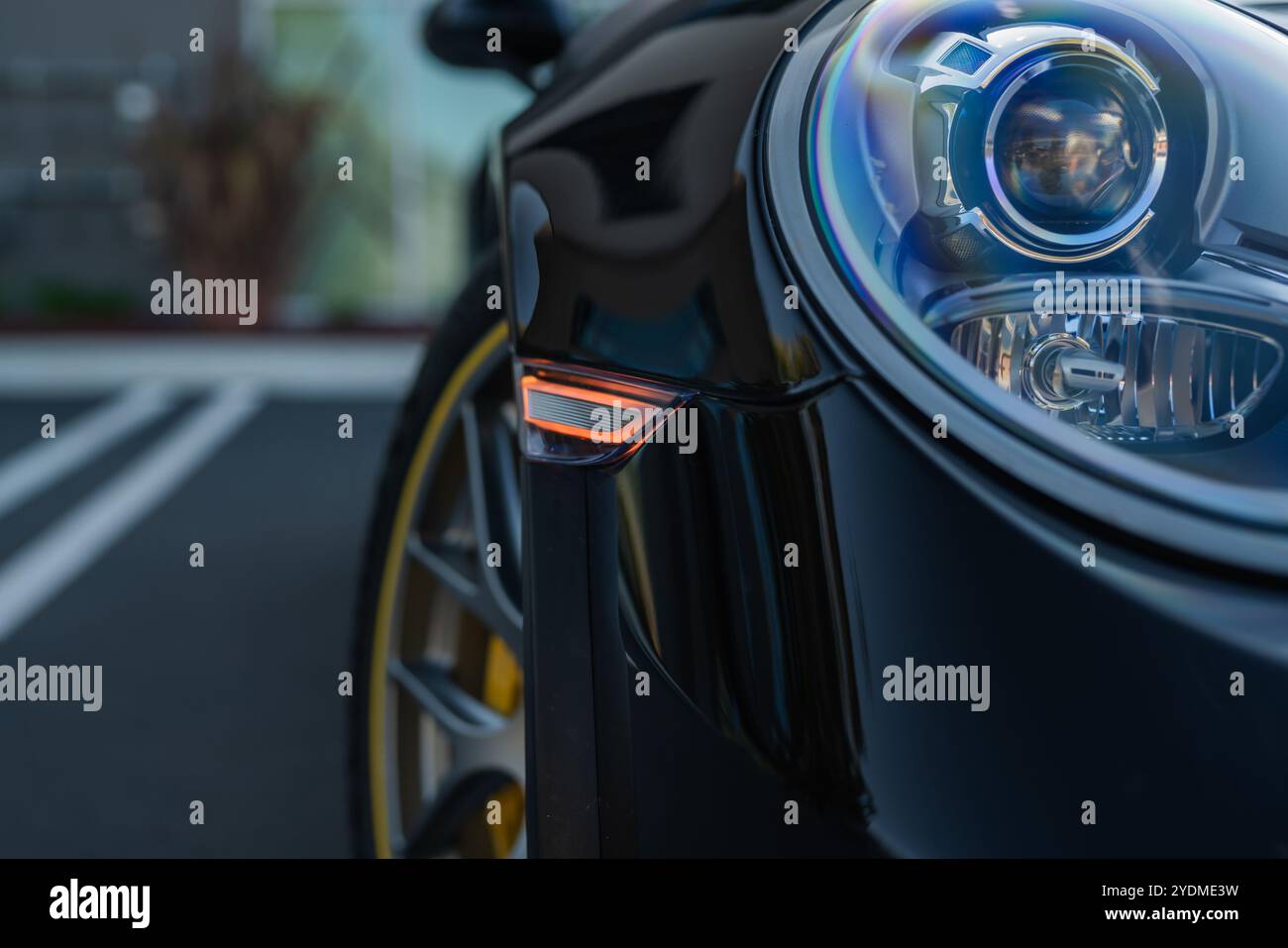 Close-up of a sleek car's LED headlight with colorful reflections on a ...