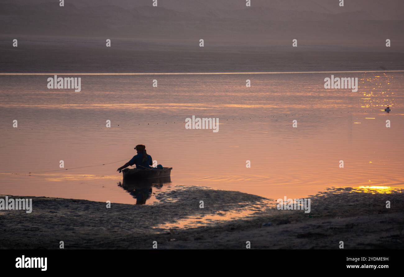 Fisherman fishing with boat in river in morning sunlight with beautiful ...