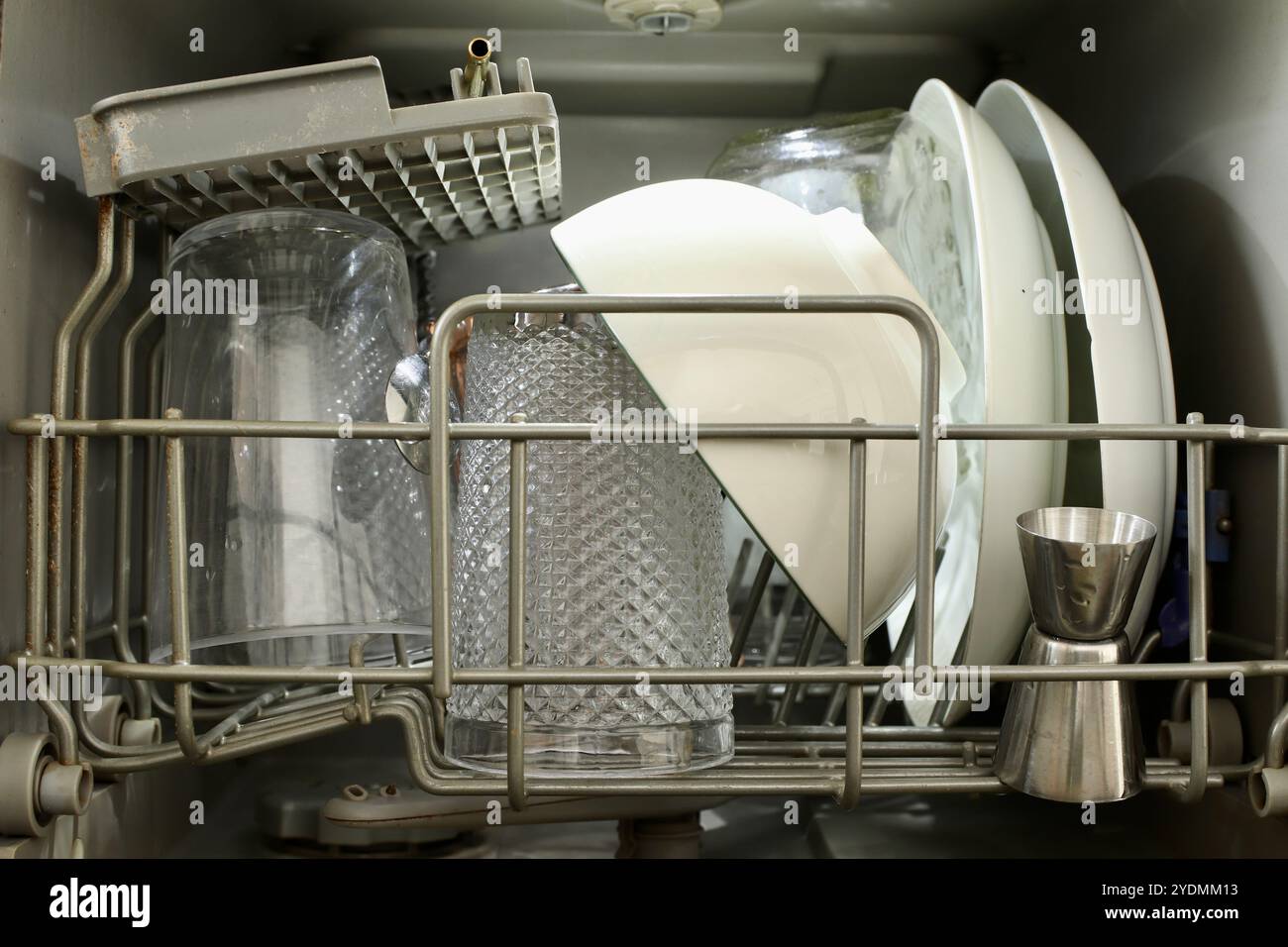 Inside dishwasher view. Washing dishes background. Full shelf with load ...