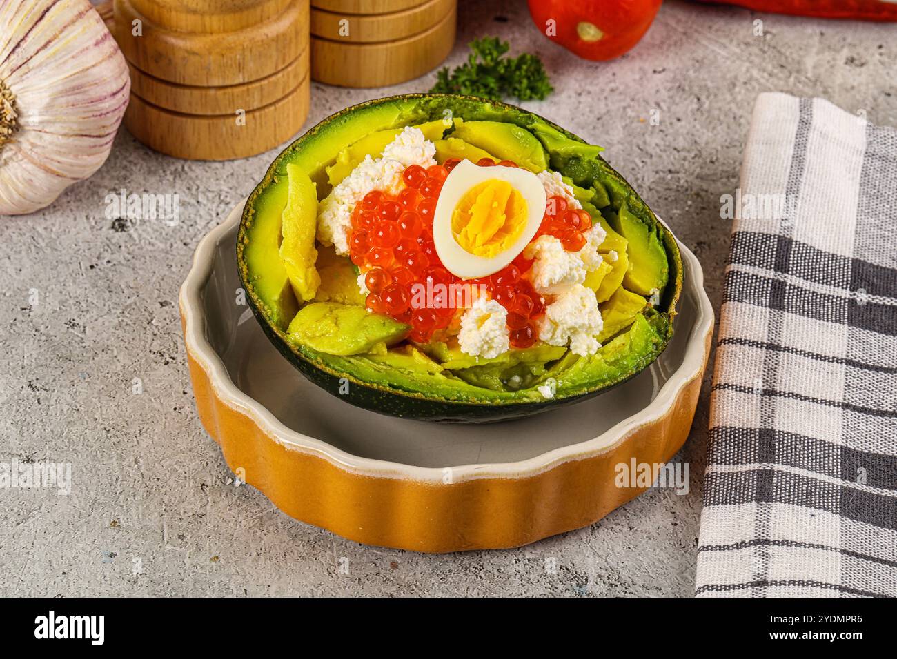 Avocado with red caviar and quil egg and soft cheese Stock Photo - Alamy