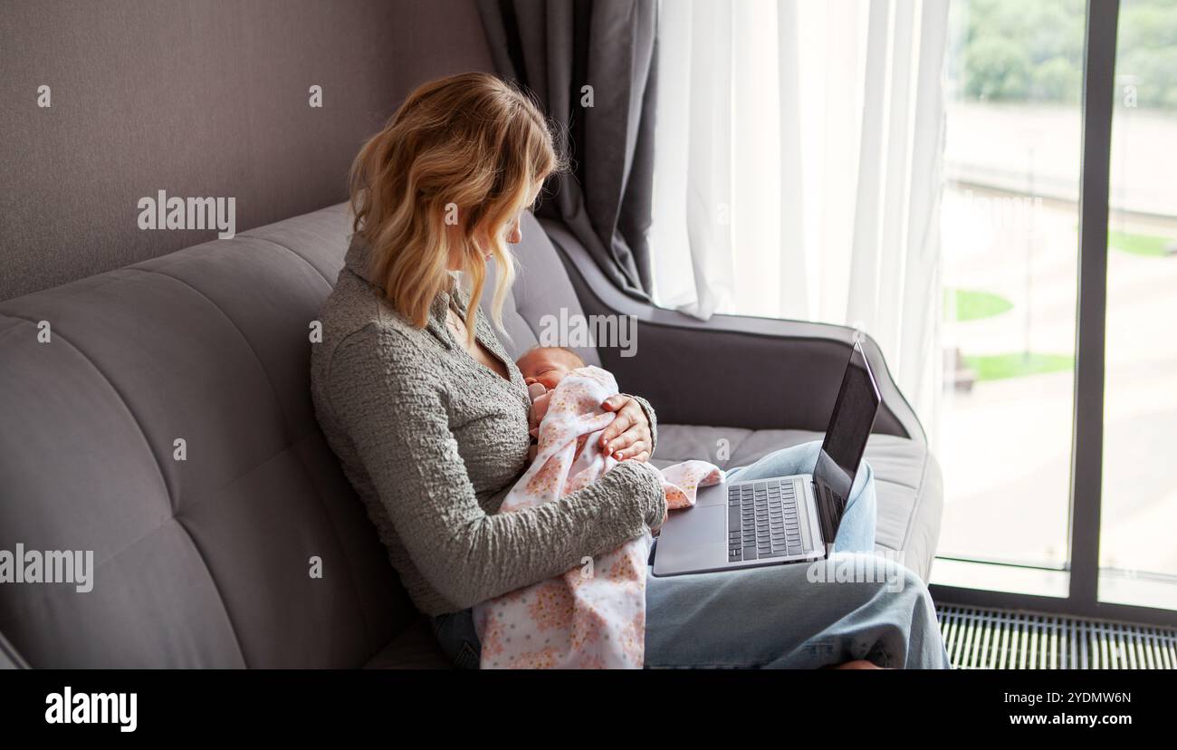 Working mother with sleeping newborn baby in arms, multitasking with ...