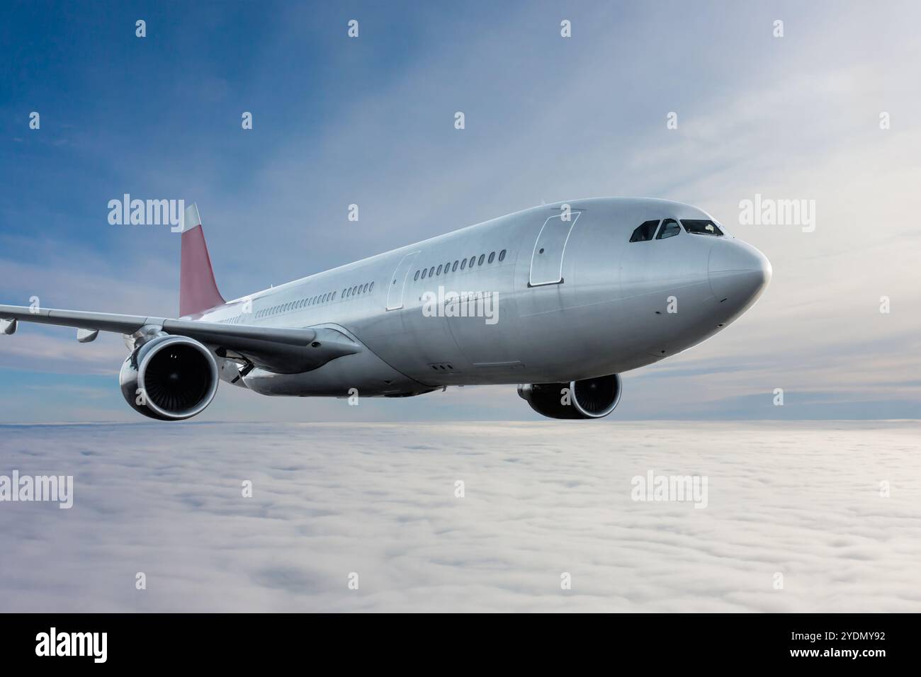 Wide body passenger jet plane flies in the air above the clouds Stock ...