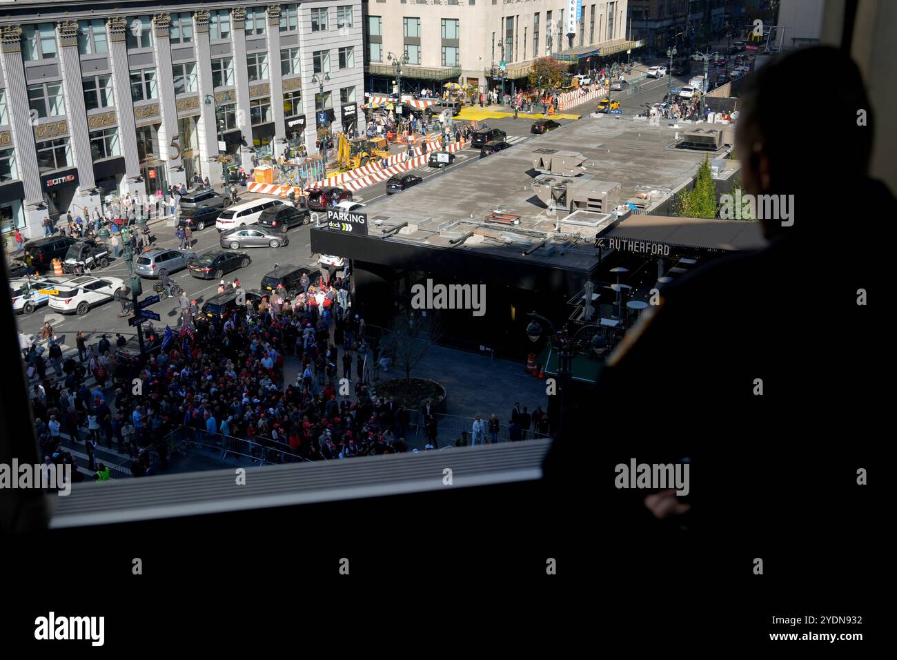 A police officer looks over the crowd lined up before a campaign rally ...
