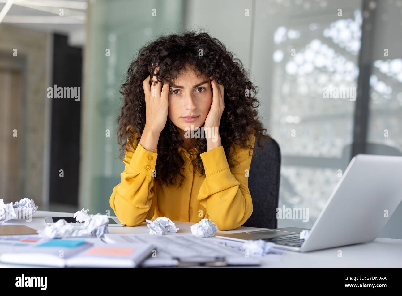 Stressed Latin American businesswoman in yellow shirt feels pressure at ...