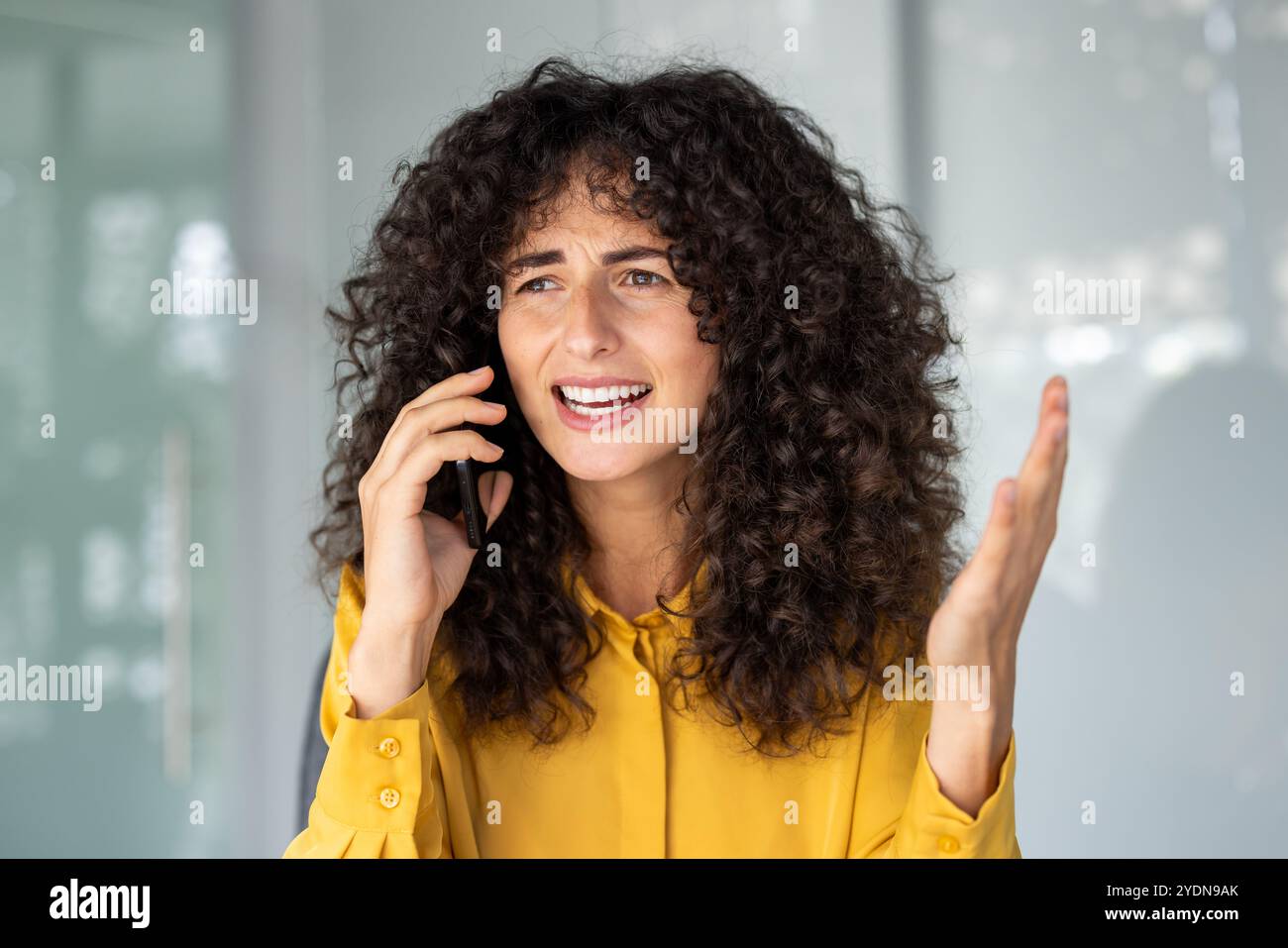 Latin American businesswoman expressing confusion during phone call ...