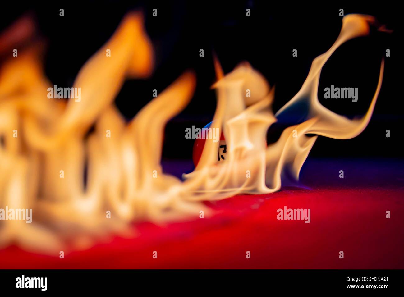 A billiard table is engulfed in flames, with blazing balls scattering ...