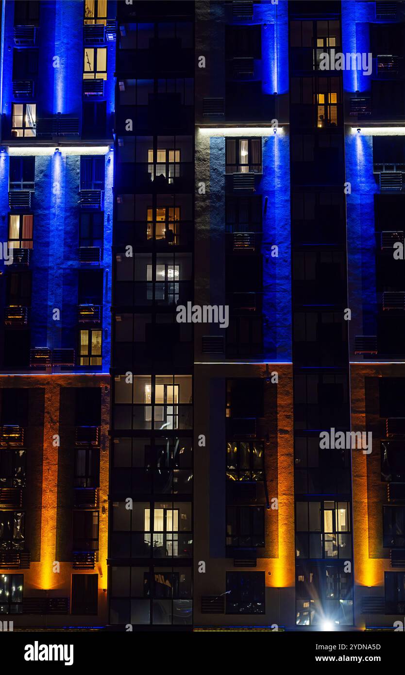 Modern apartment building facade illuminated with vibrant lights at ...