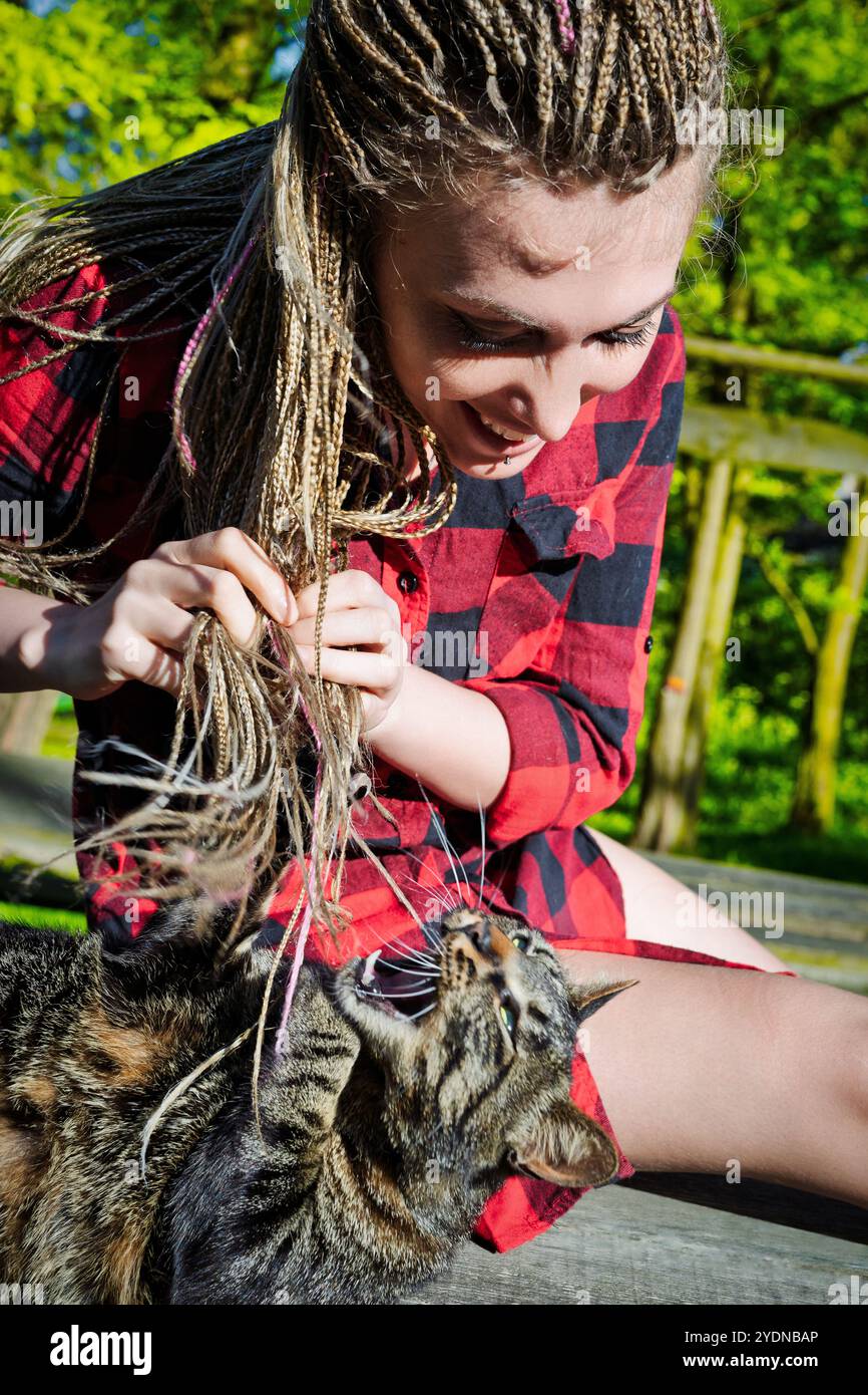 Young woman with long braids wearing a red and black checkered shirt ...