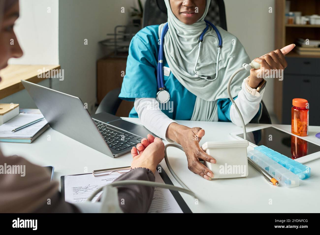 Muslim medical professional engaging with patient, processing medical ...