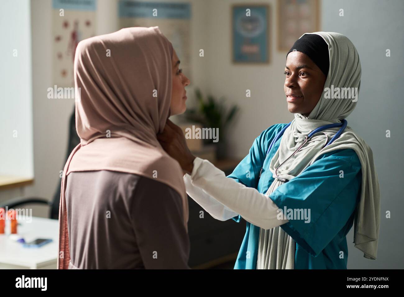 Muslim healthcare professional wearing stethoscope, attending patient ...
