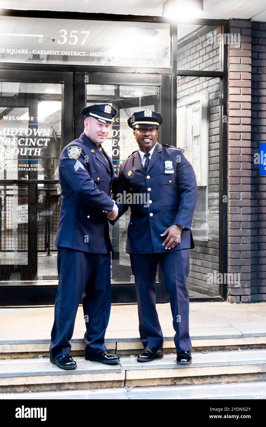 Two graduating police officers wearing uniforms shake hands on the ...