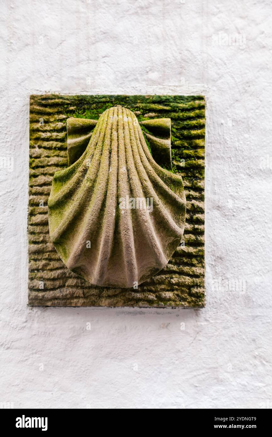 A shell symbol, representing pilgrimage, is affixed to a rustic brick ...