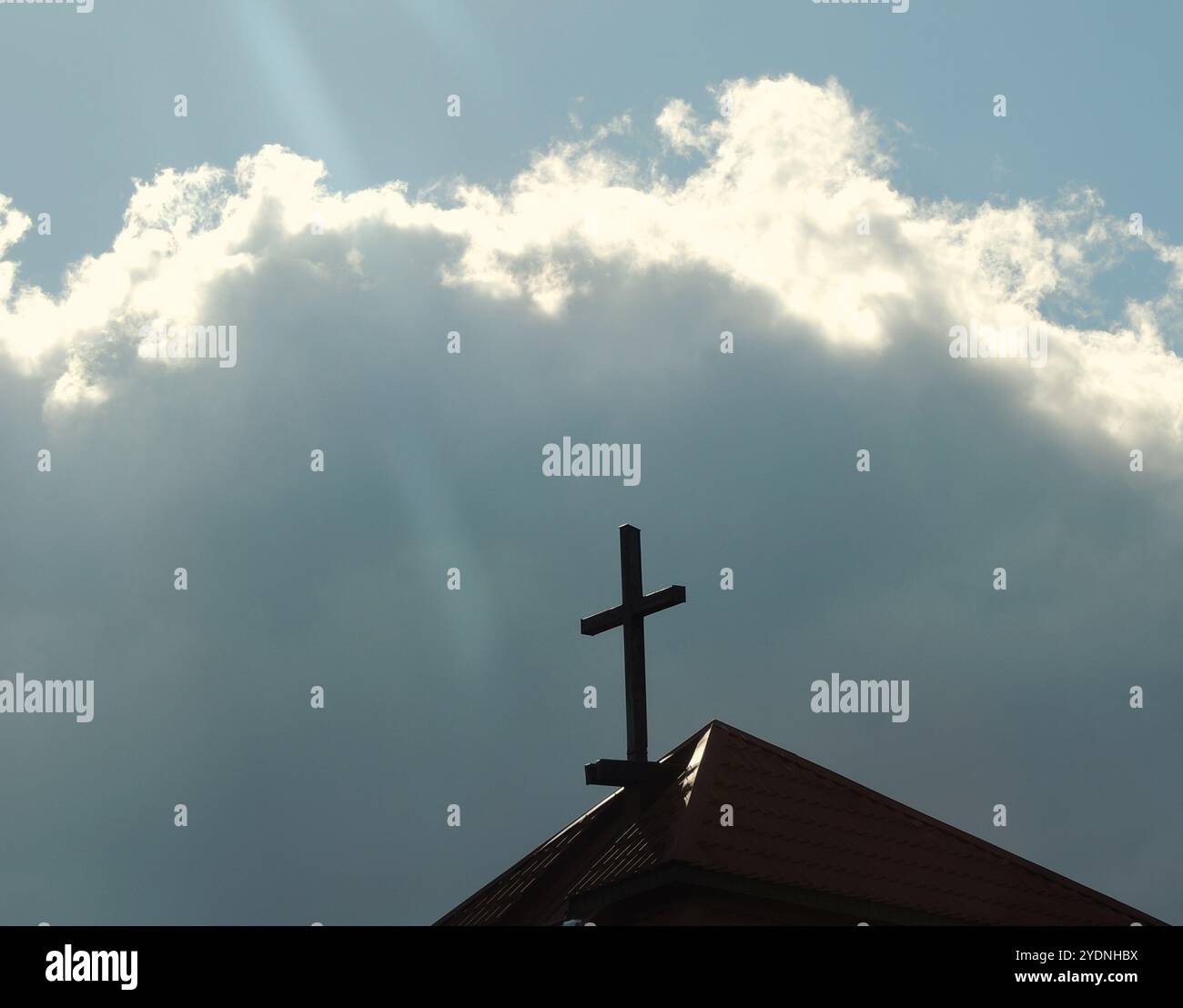 simple dark cross on top of protestant church roof against stormy ...