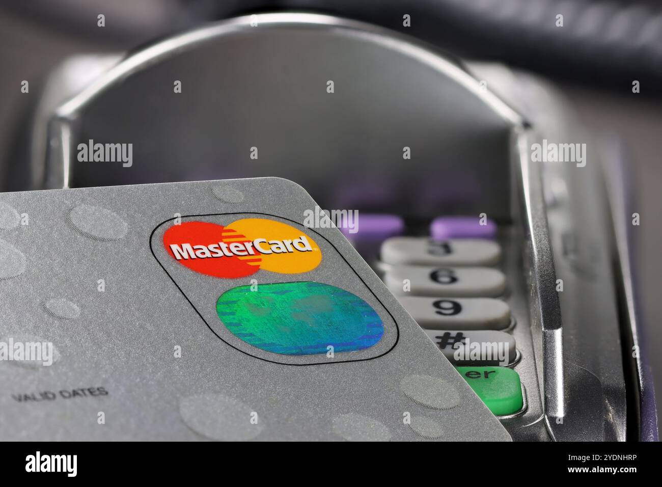 Mastercard logo on credit card with payment terminal in the background ...