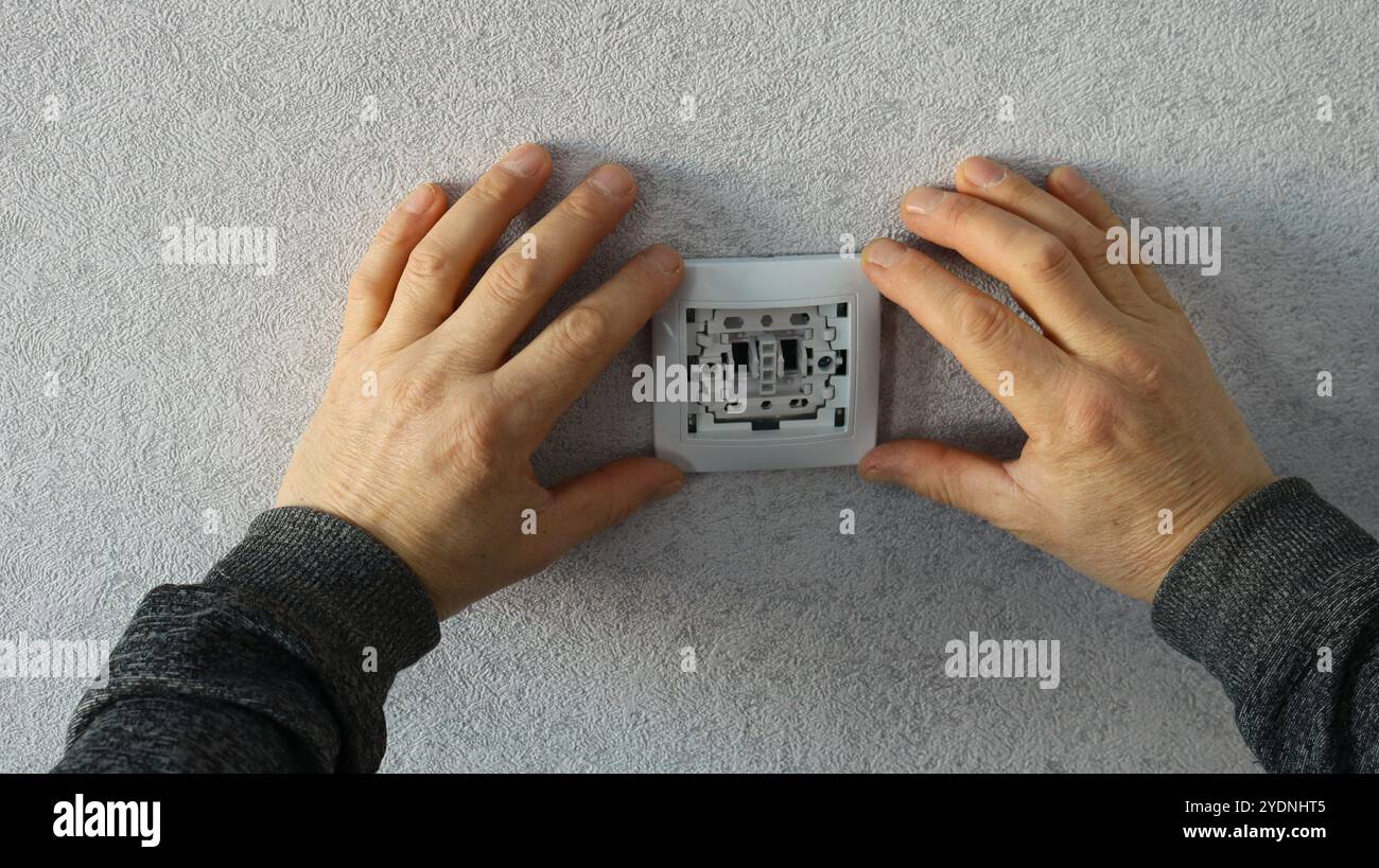 worker fixing or maintaining an electrical outlet or light switch ...