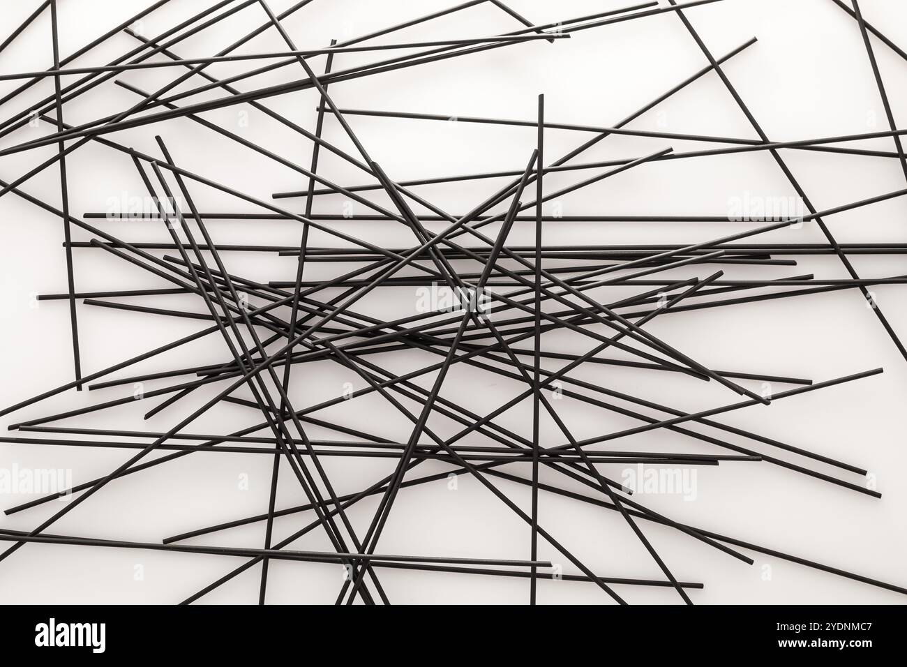 Tangled arrangement of raw black spaghetti lying on white surface ...
