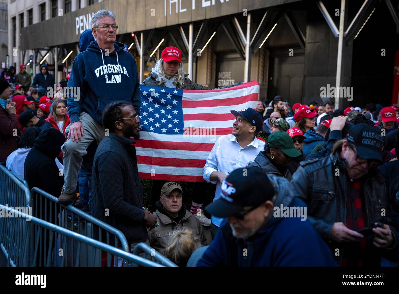 Trump supporters crowd together in line with an American flag ahead of ...