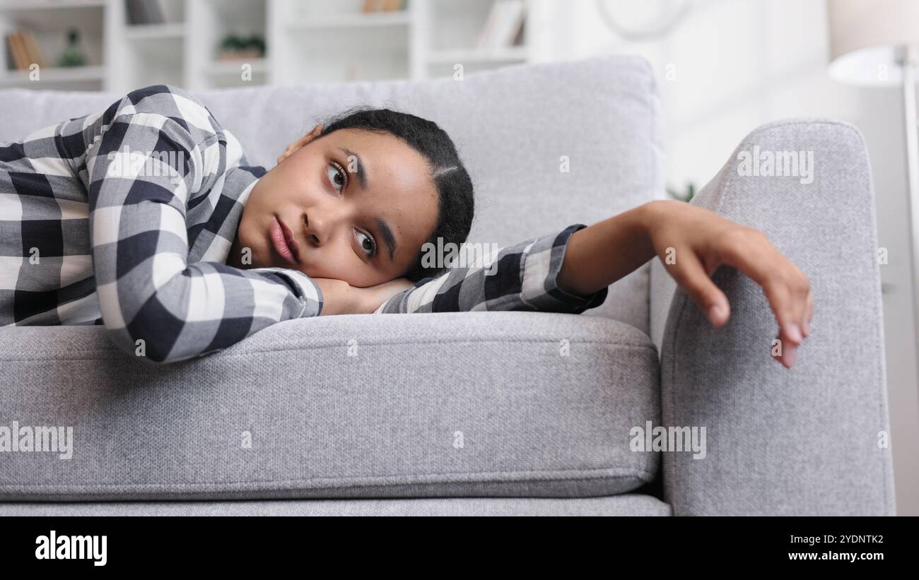 Tired african american girl lying on sofa feeling lethargic. Feeling ...