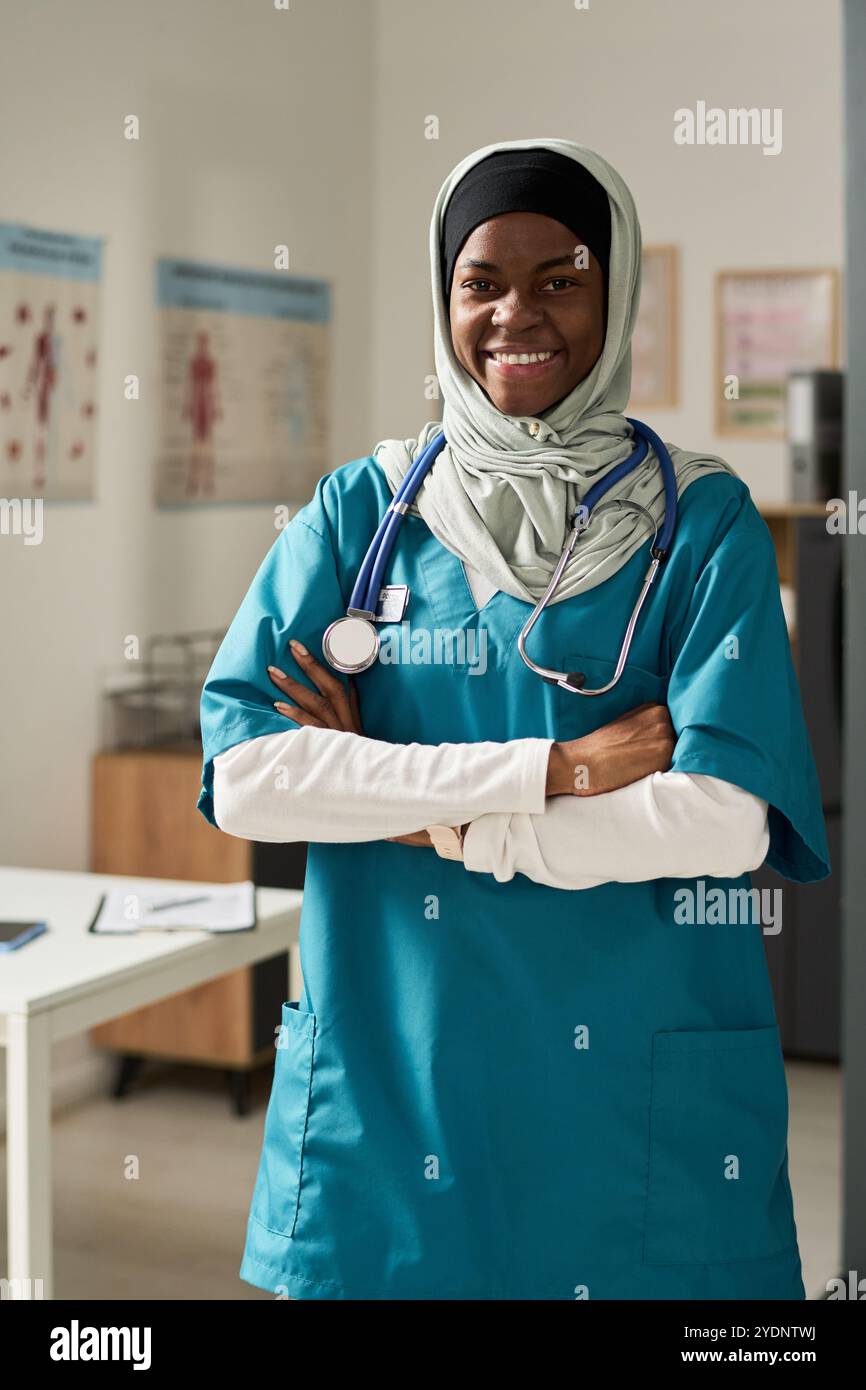 Smiling Muslim nurse standing in hospital environment, dressed in ...