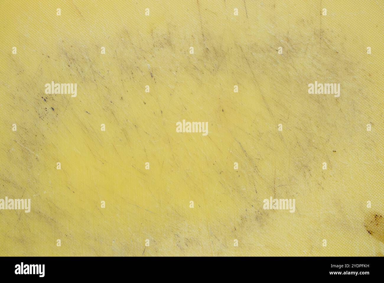 Plastic yellow cutting board all in cuts from a knife, the board is ...