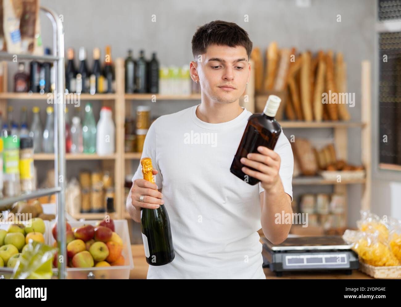 Young guy is choosing wine and whiskey in grocery store Stock Photo - Alamy