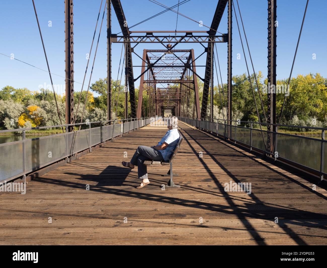 Senior woman sitting on a bench on the historic Fort Benton Bridge ...