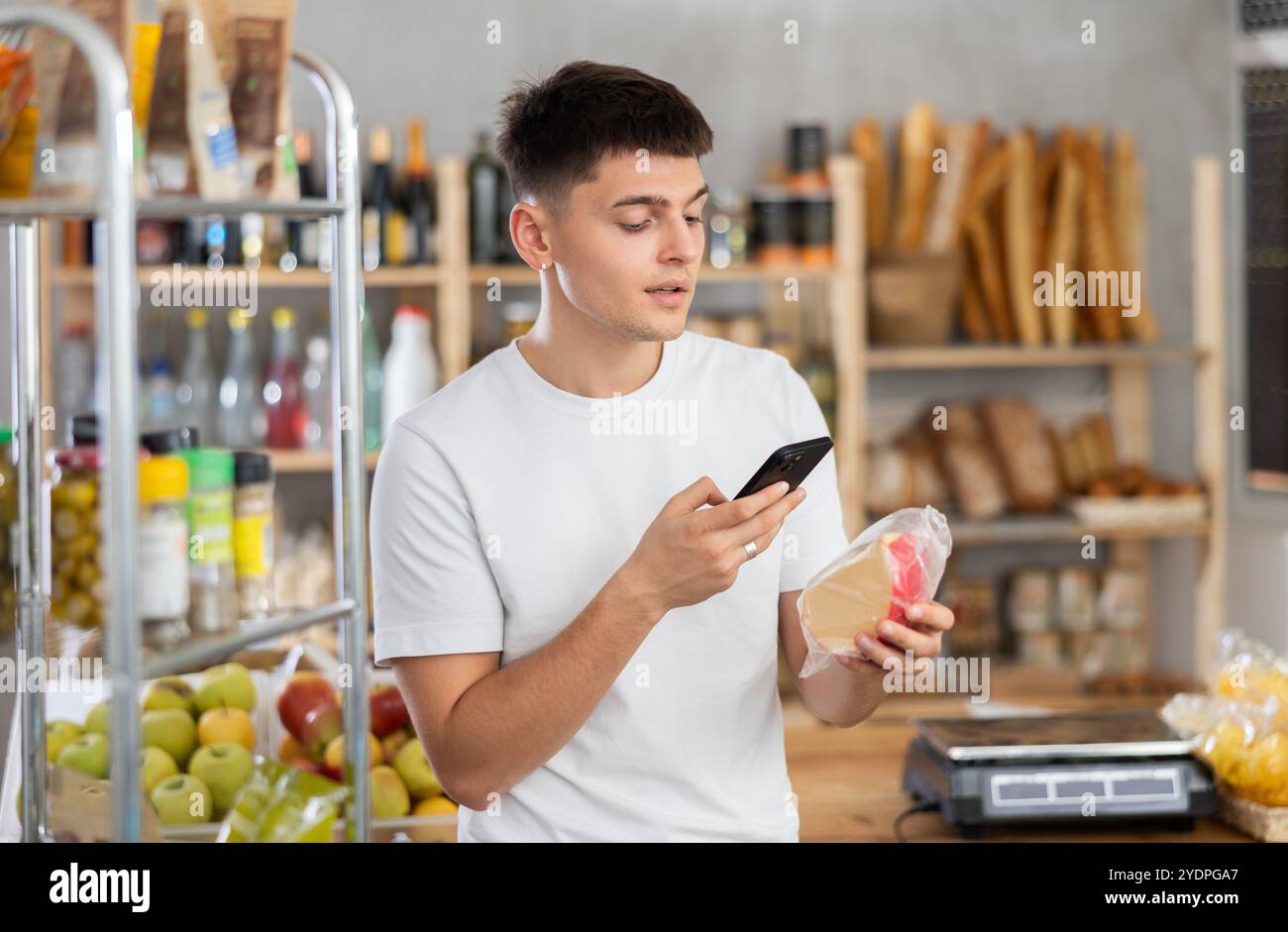 Guy purchaser scanning QR code or barcode of dried meat in supermarket ...