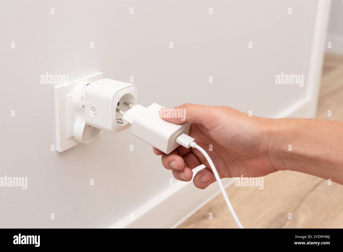 Man plug electric charger into smart socket Stock Photo - Alamy