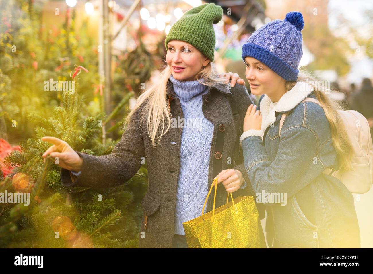 Girl and her mother purchasing christmas tree at market Stock Photo - Alamy