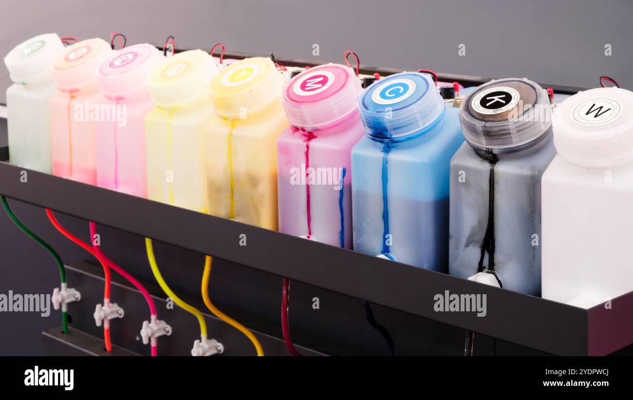 row ink tanks with different colors. tanks are connected to a machine ...
