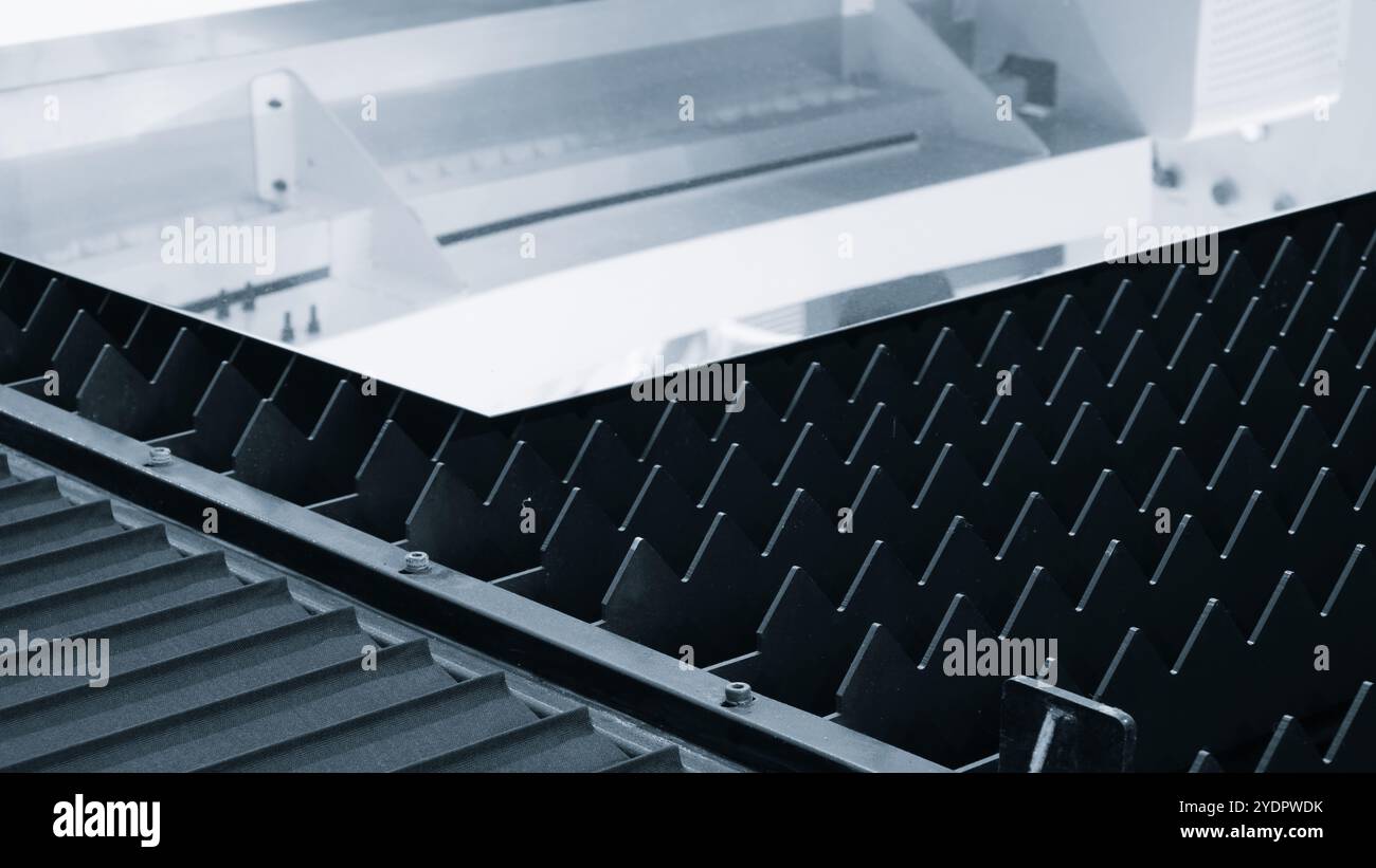 Shiny metal sheet lies on table of industrial laser cutting machine ...