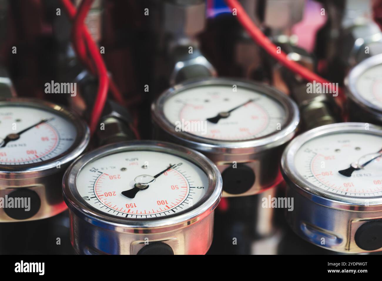 Four white and red dials with red wires attached to them. The dials are ...