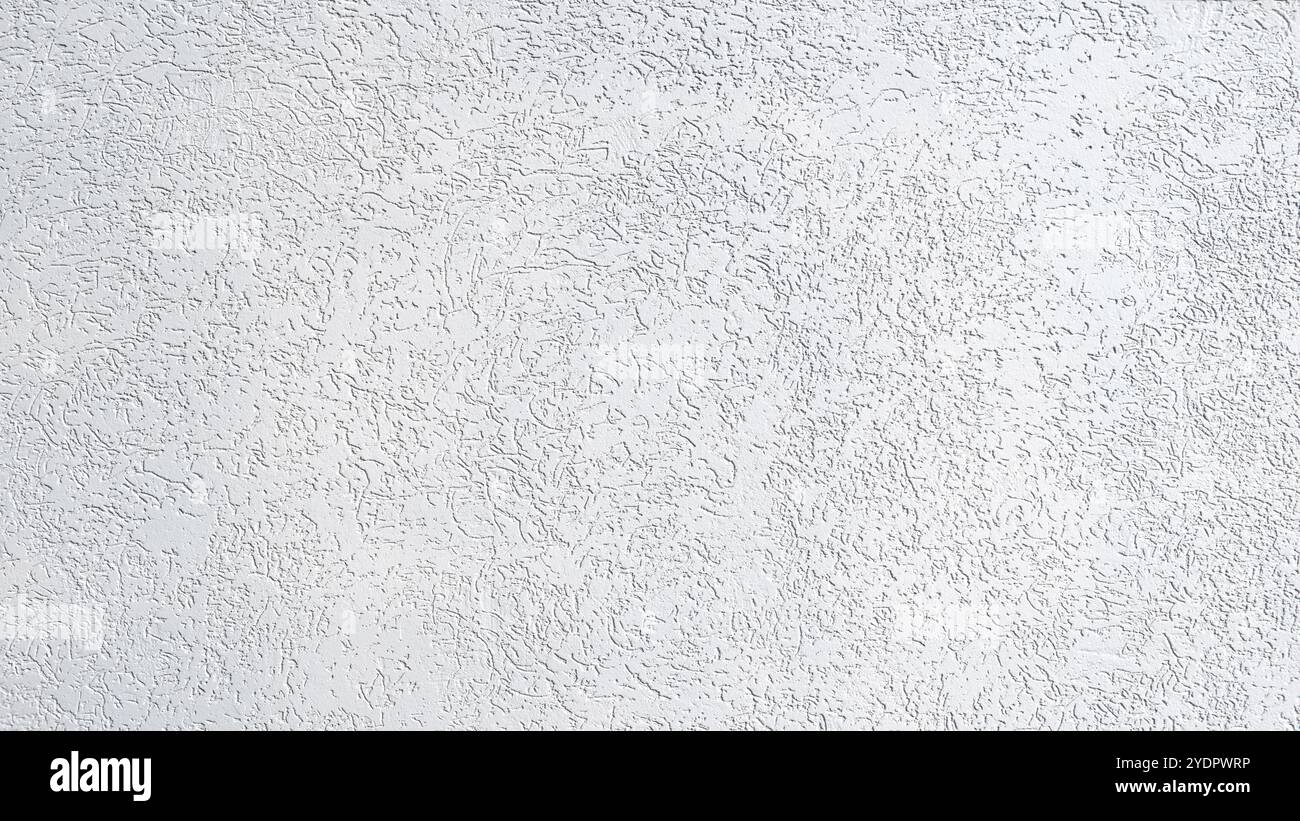 A white wall with a rough texture. The wall is covered in small white ...