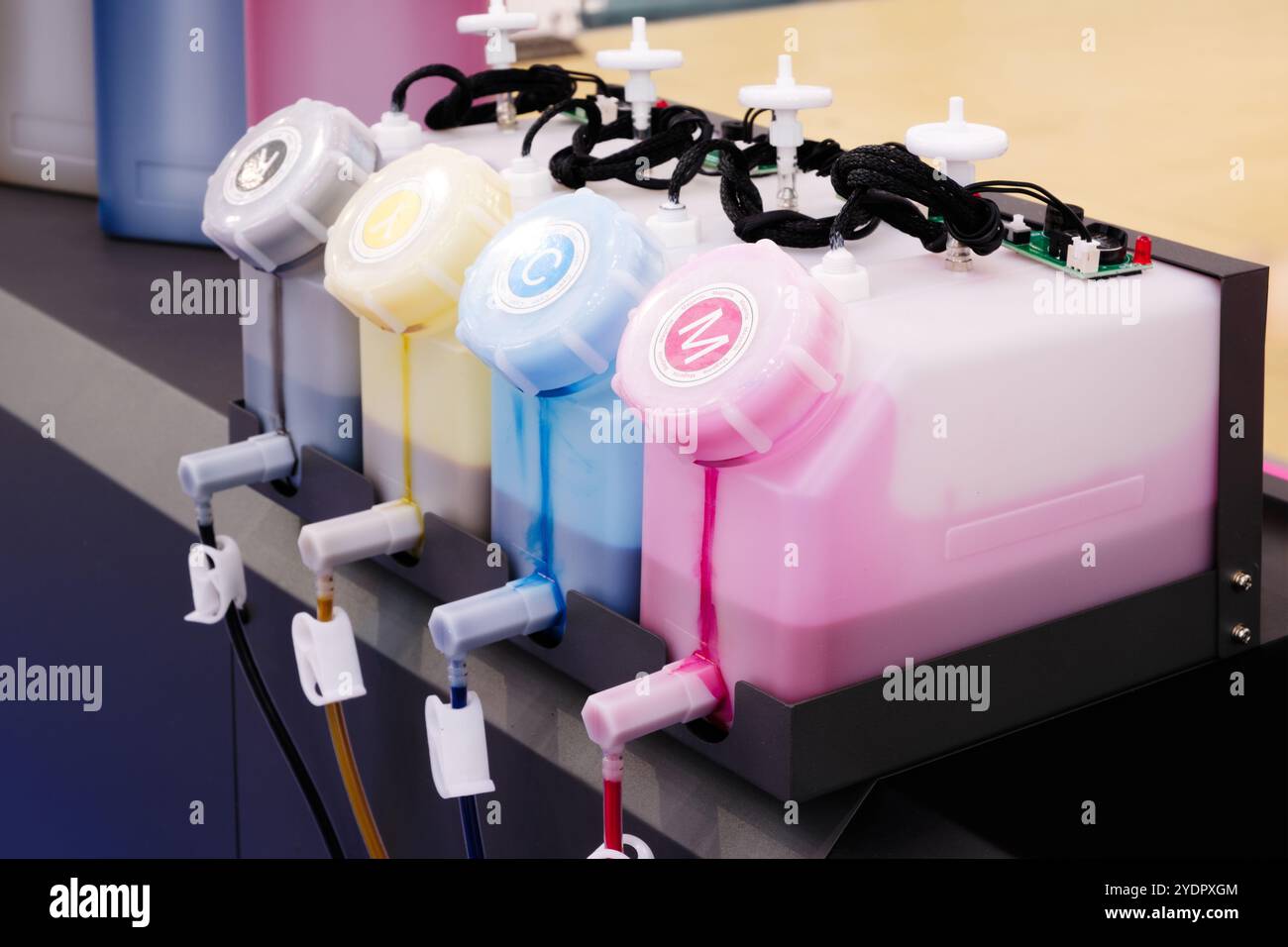 row ink tanks with different colors. tanks are connected to a machine ...