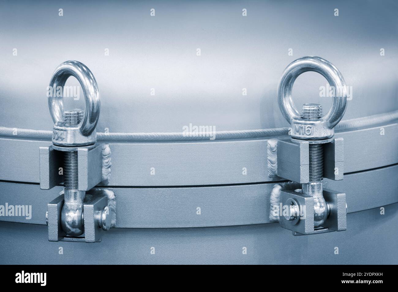 Two metal screws hold the lid of an industrial stainless steel chemical ...